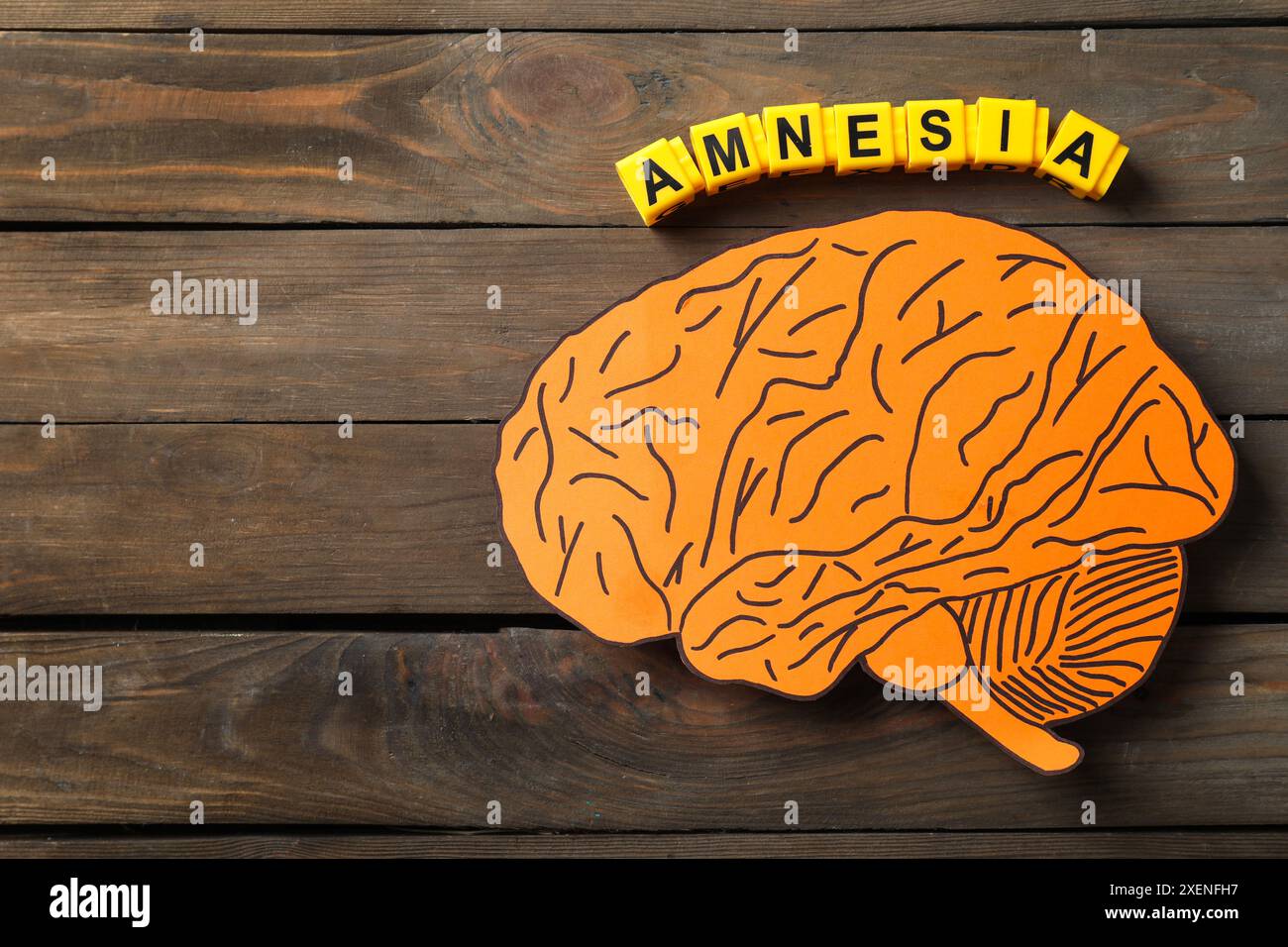 Yellow cubes with word Amnesia and paper cutout of human brain on ...