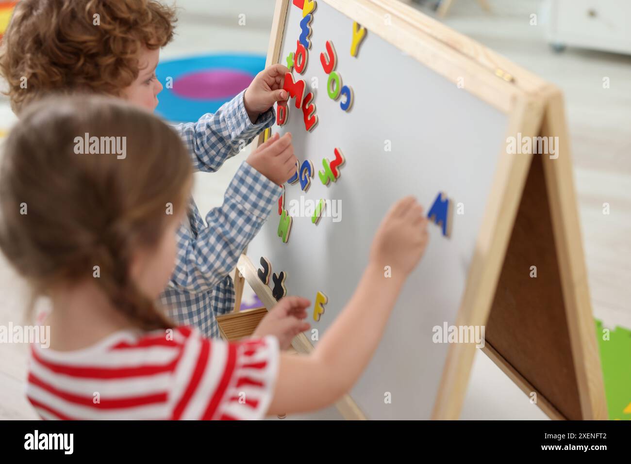Little children learning alphabet with magnetic letters on board in ...