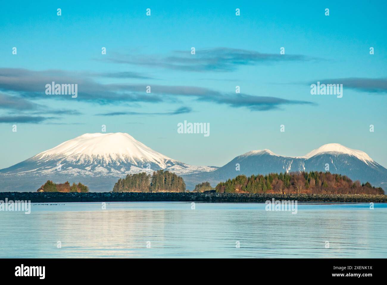 USA, Alaska, Sitka. Snow-covered Mt. Edgecumbe volcano and rock barrier ...
