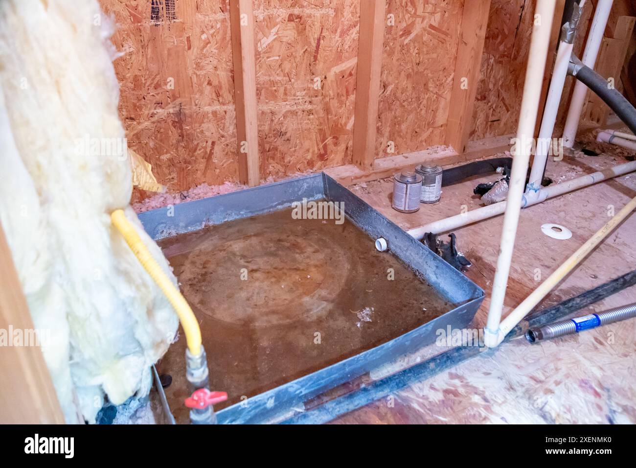 Water heater drain pan in attic, full of water Stock Photo - Alamy