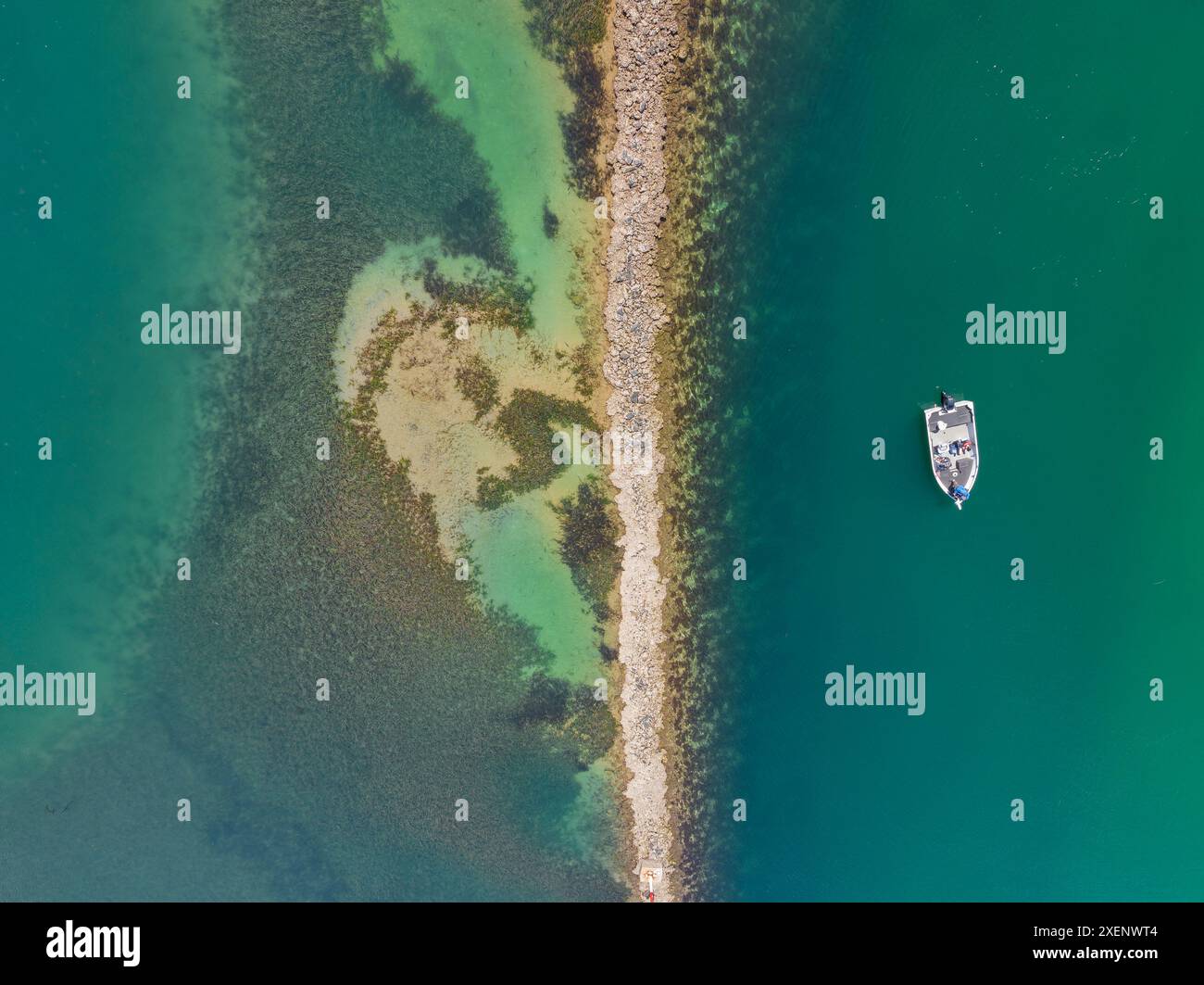 Aerial view of a small boat anchored in a calm coastal bay at Narooma ...