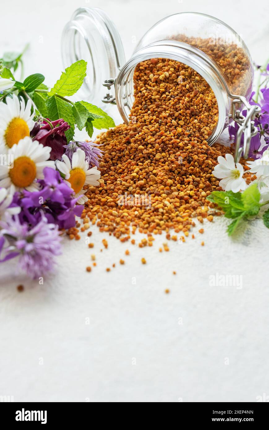 Healthy bee pollen grains. Bee pollen on a glass jar and wild flowers ...