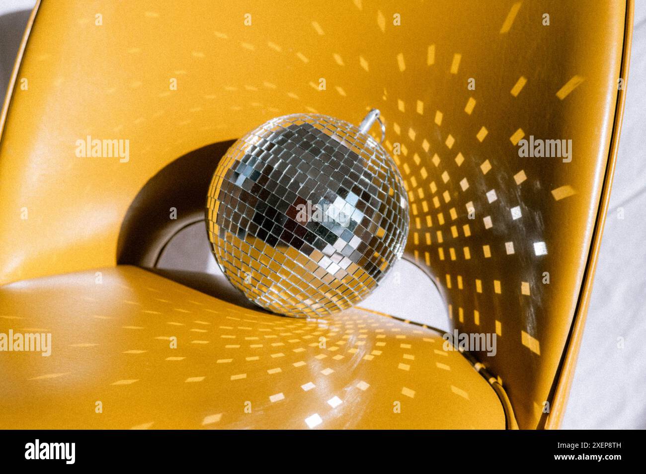 Disco Ball on yellow chair Stock Photo - Alamy