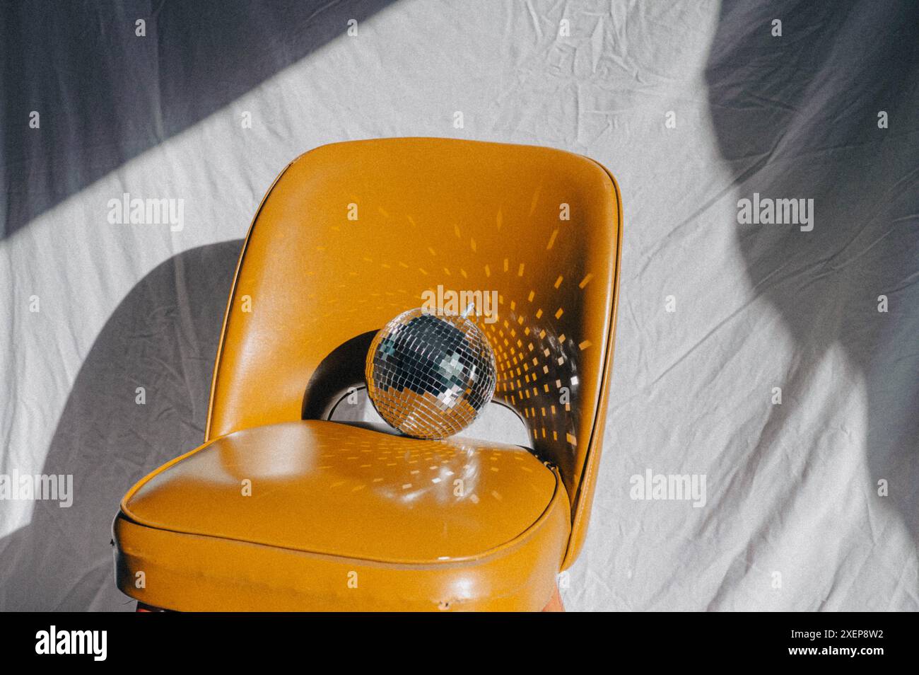 Disco Ball on yellow chair Stock Photo - Alamy
