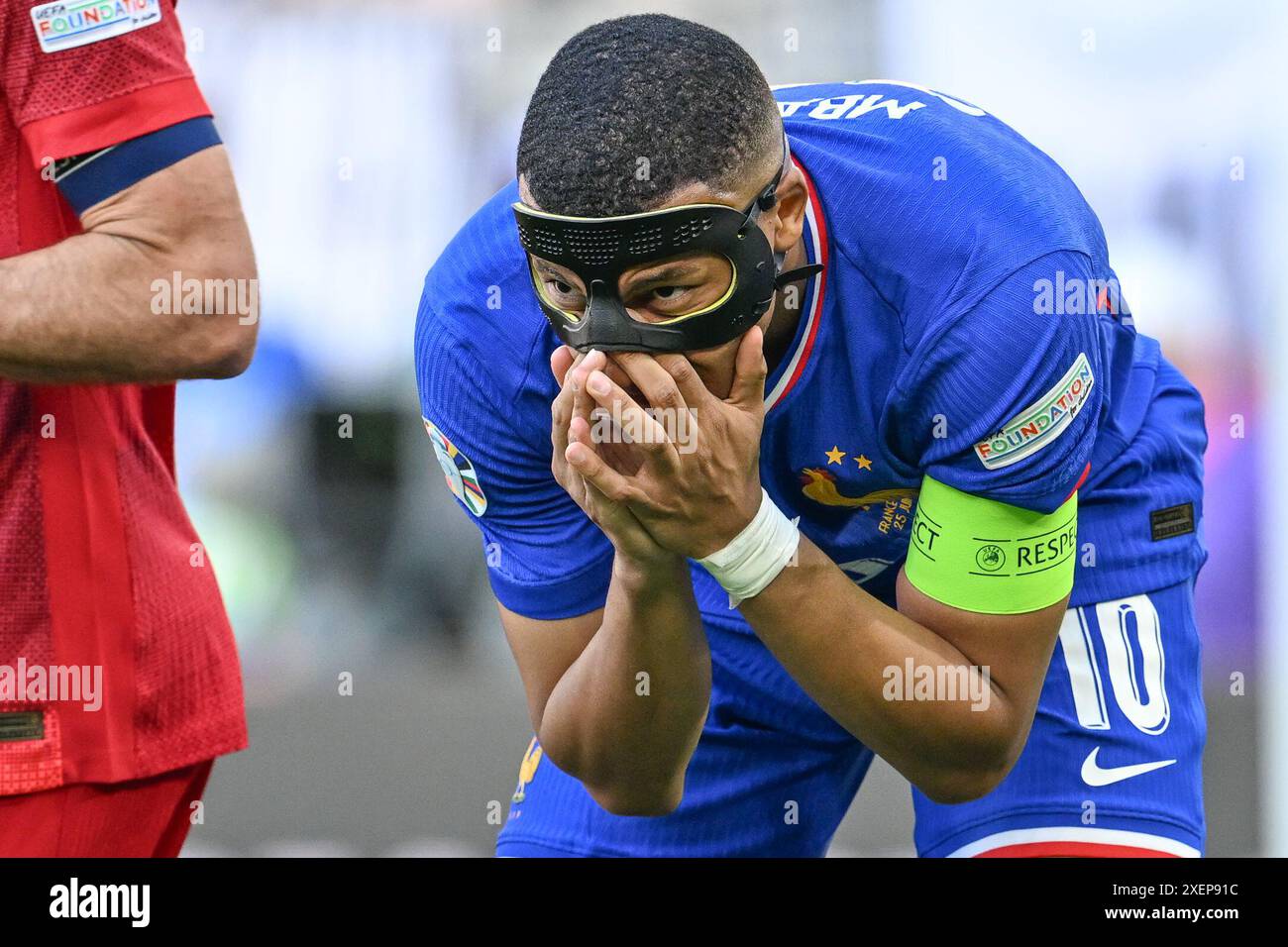 Kylian Mbappe (10) of France in pain and checks his nose under his mask ...