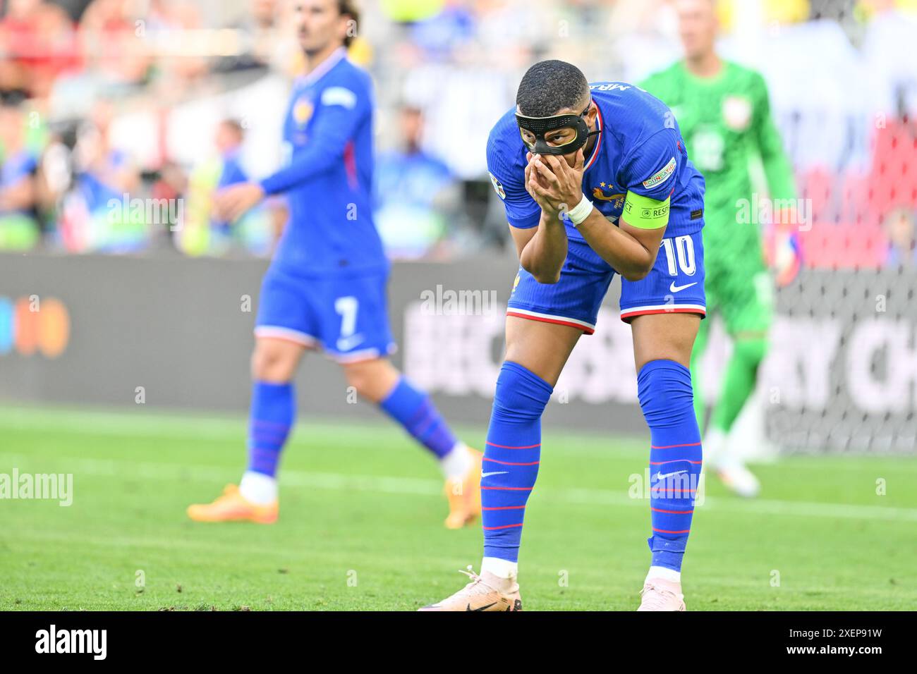 Kylian Mbappe (10) of France in pain and checks his nose under his mask ...