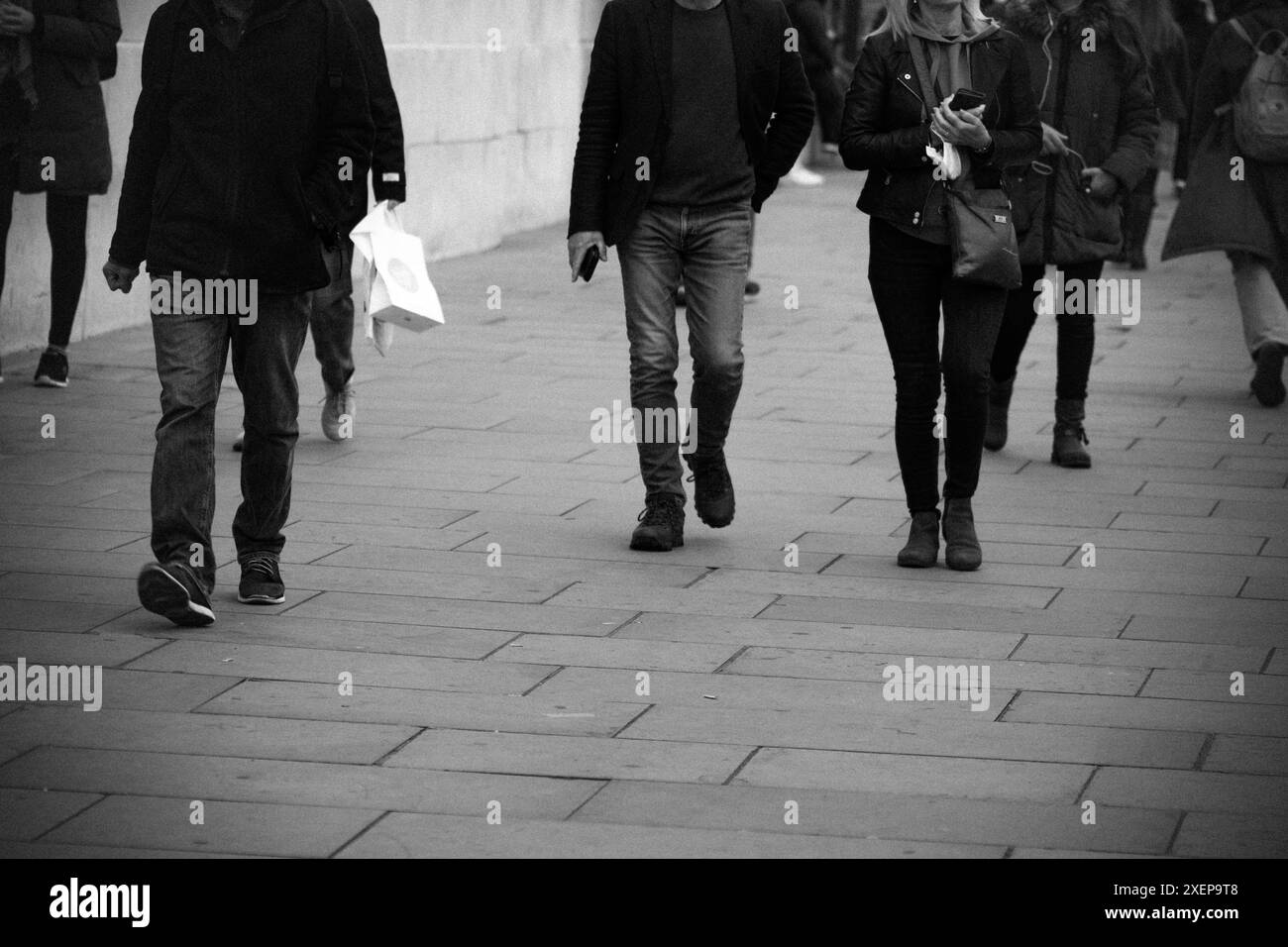 legs of pedestrians and shoppers walking along the pavement Stock Photo ...