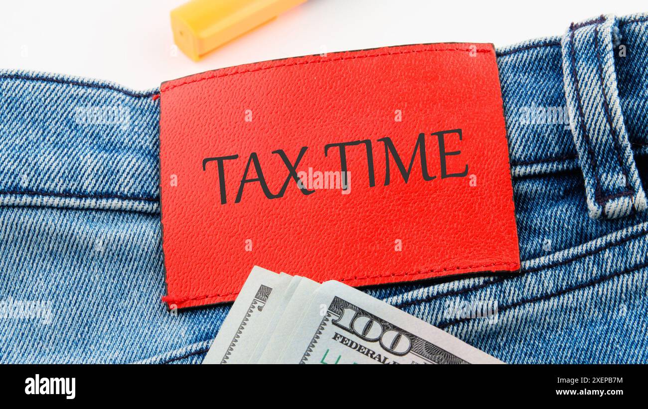 Business and tax concept. TAX TIME on the red leather label of jeans on ...