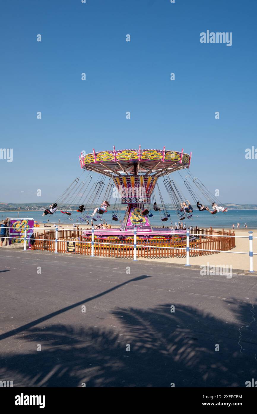 Swing carousel on Weymouth beach on a summer day with blue skies Stock ...