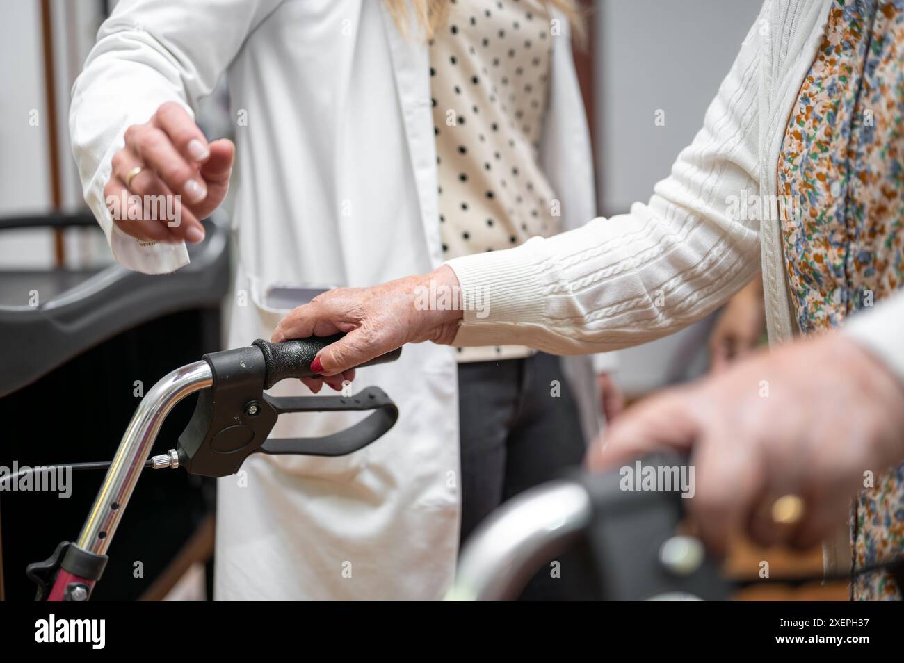Nurse helping old woman to walk at nursing home with walker. Young ...