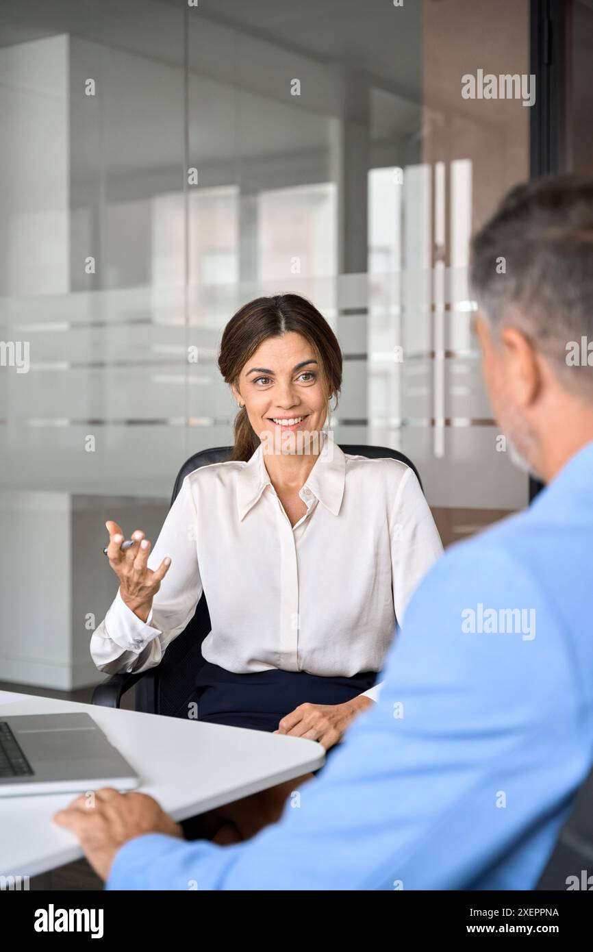 Happy female professional bank manager consulting client at office ...