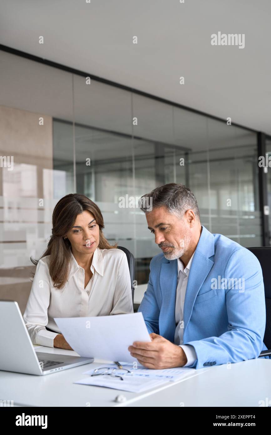 Two busy mature business leaders working together in office at meeting ...