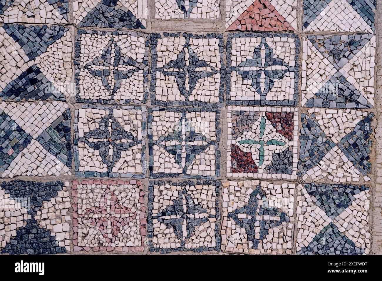 A mosaic tile floor with a pattern of squares and triangles. The tiles ...