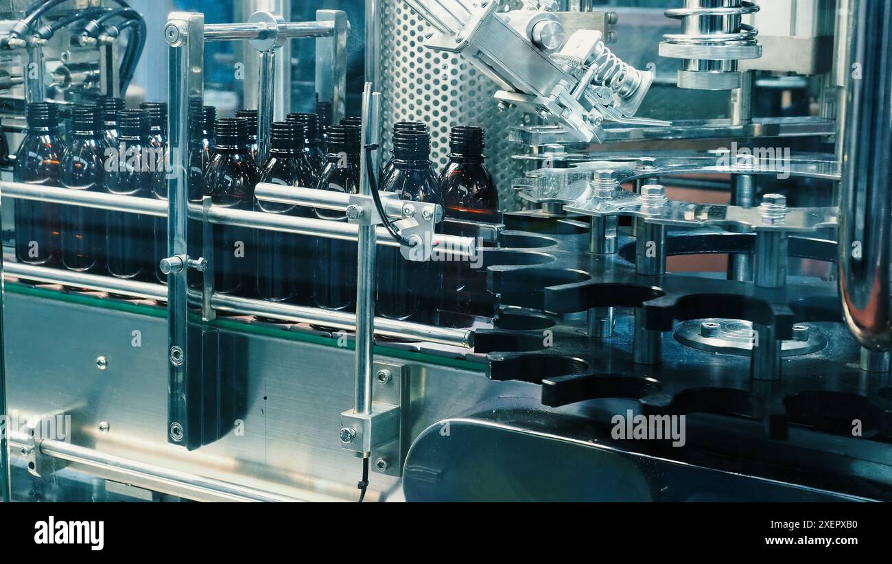 Bottles filling automation machine in modern factory. Technology ...
