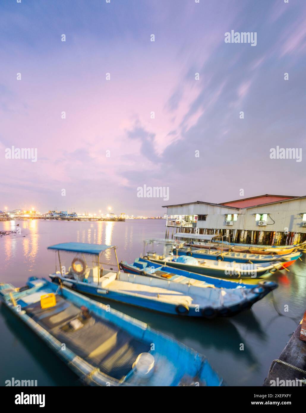 Beautiful pink skies,small boats bobbing in the calm sea waters of the ...