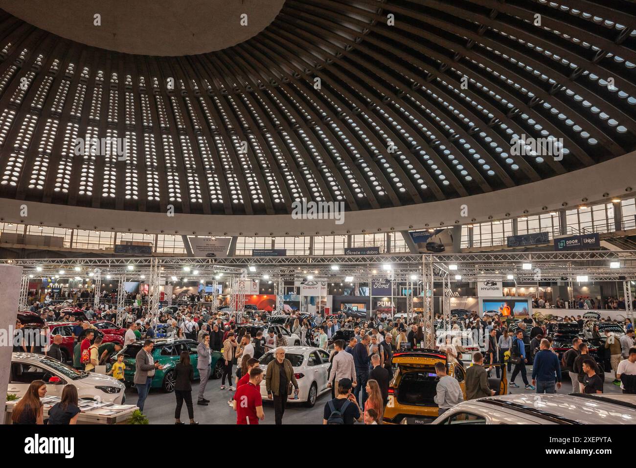 This image captures a crowded car dealership in Belgrade. The bustling ...