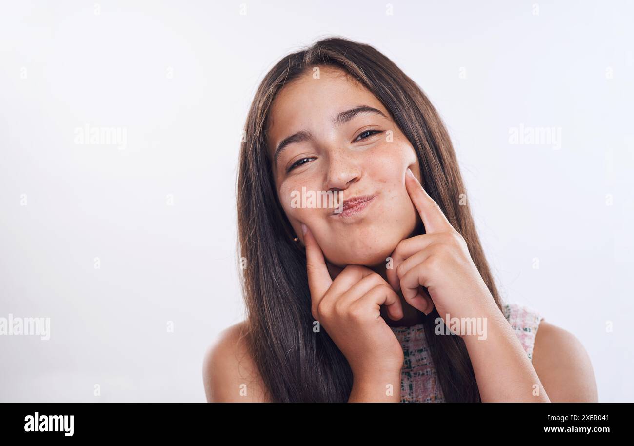 Girl, teenager and funny face with cheeks in studio portrait for joke ...