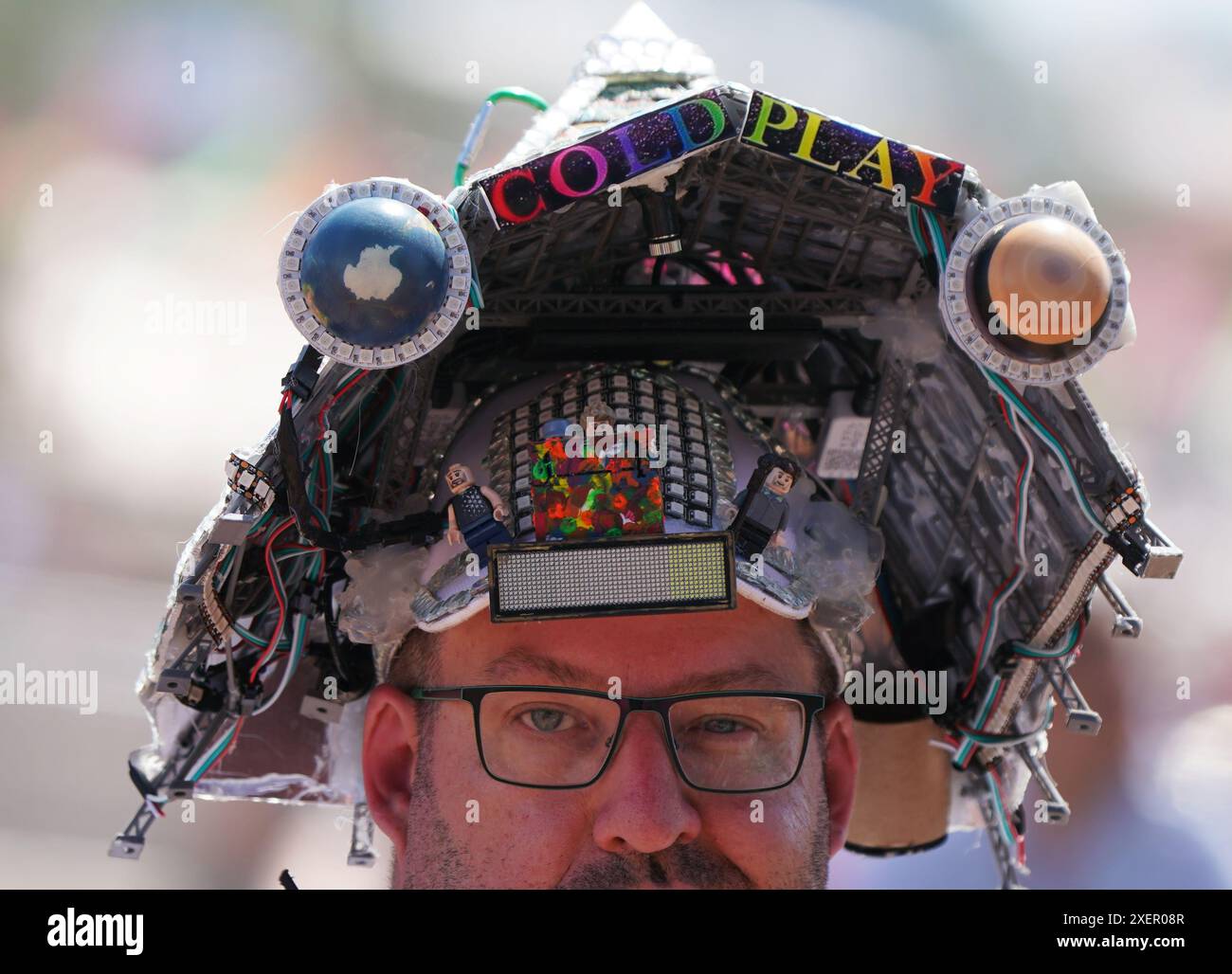 A festivalgoer wearing a Pyramid Stage Coldplay hat at the Glastonbury ...