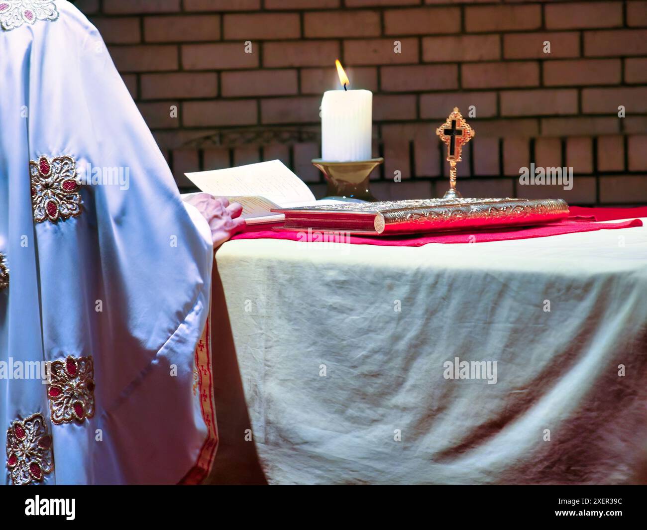 orthodox priest in the altar reading from the bible crucifix and lit ...
