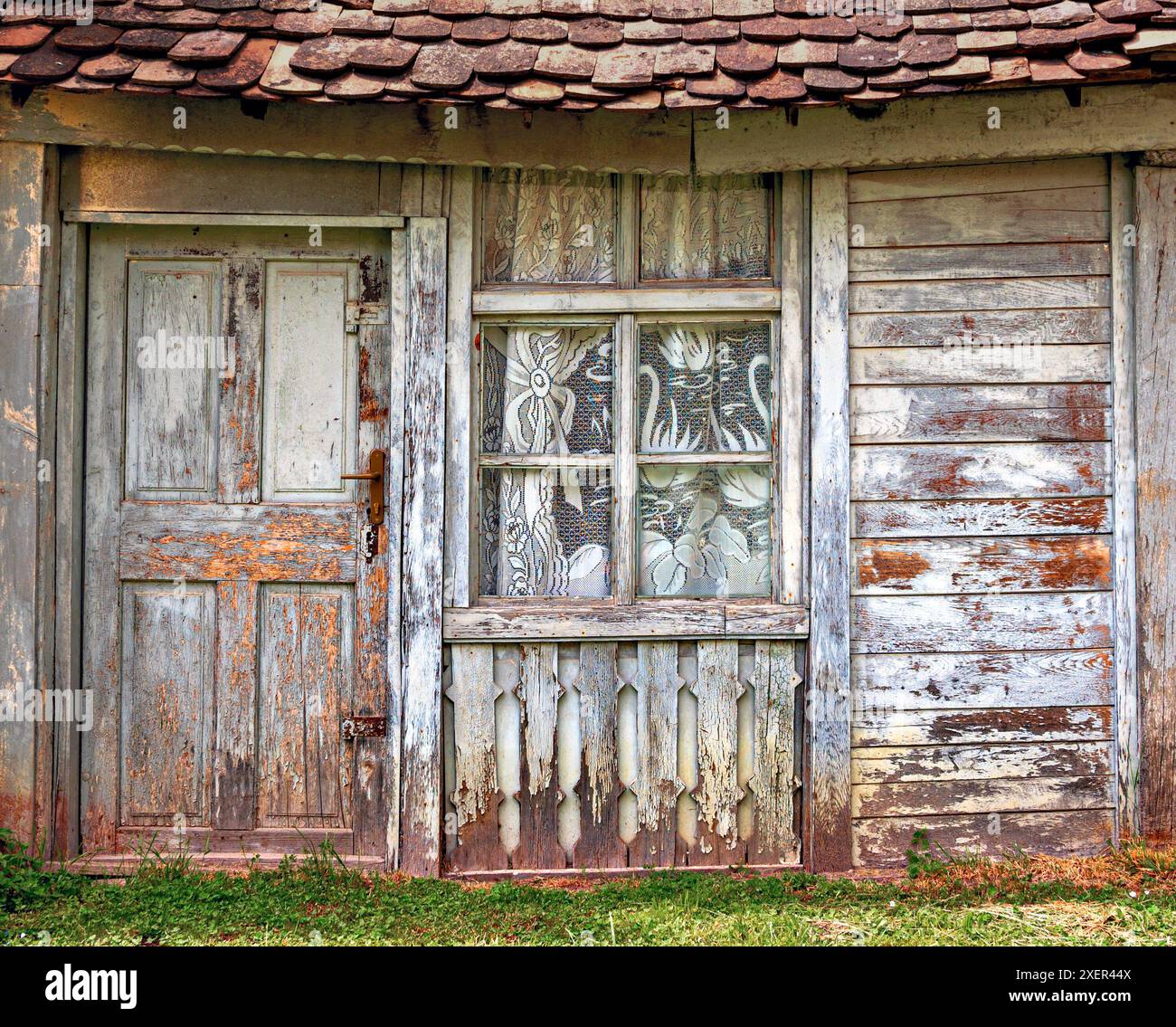 abandoned rotten wooden hut with door and window with curtain on the ...