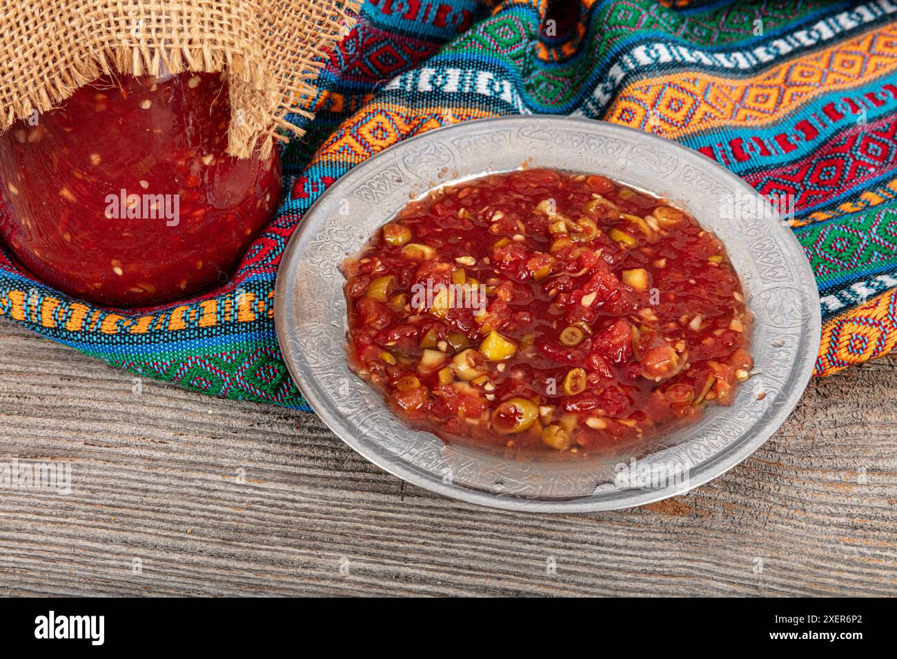 Turkish meze, acili ezme or spicy paste on wooden background. A spoon ...