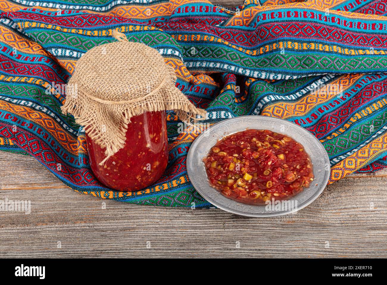 Turkish meze, acili ezme or spicy paste on wooden background. A spoon ...