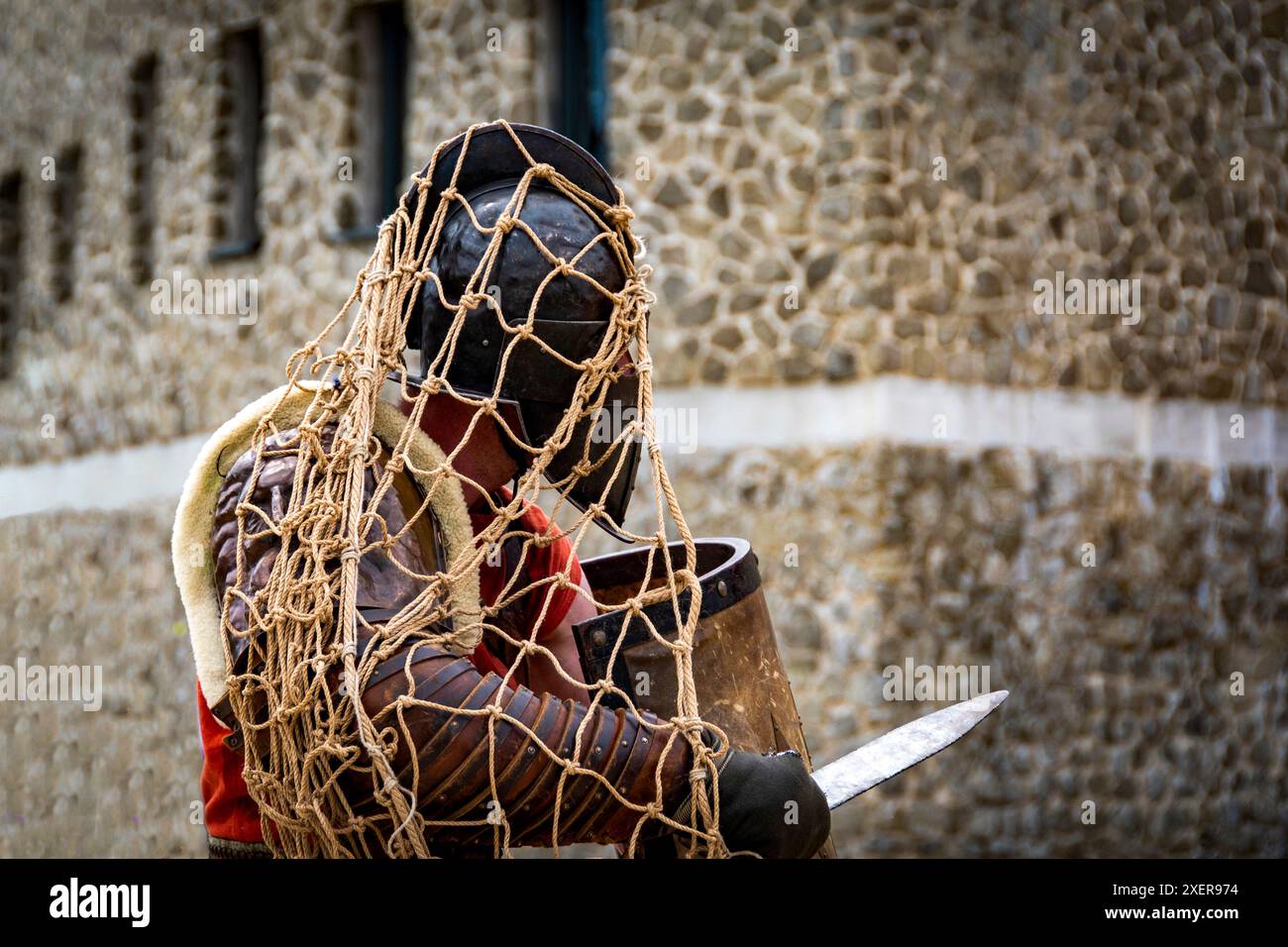 Roman gladiator in traditional armor with netting wrapped around his ...