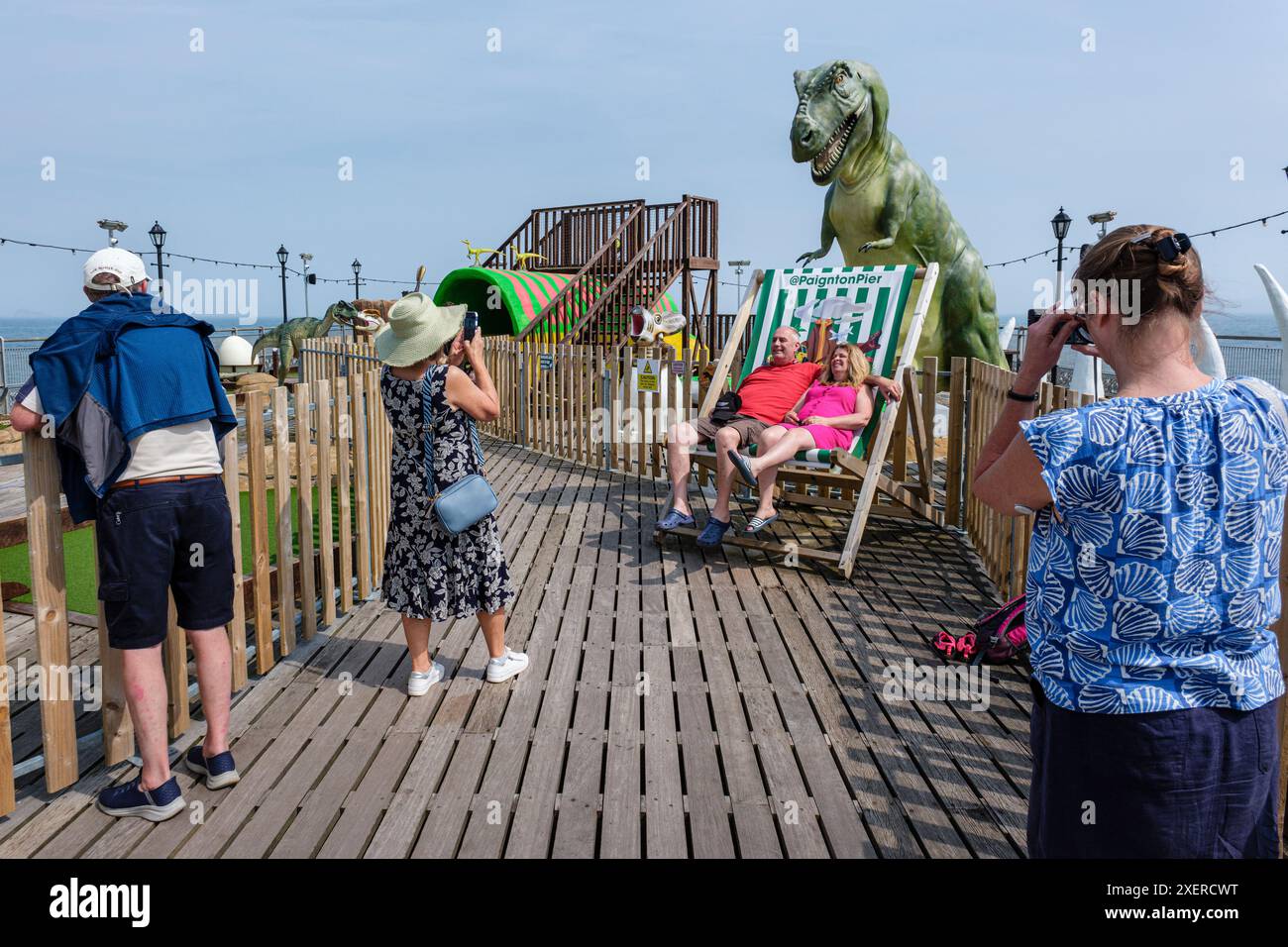 Visitors pose for a holiday snap sitting on a giant deckchair, Paignton ...