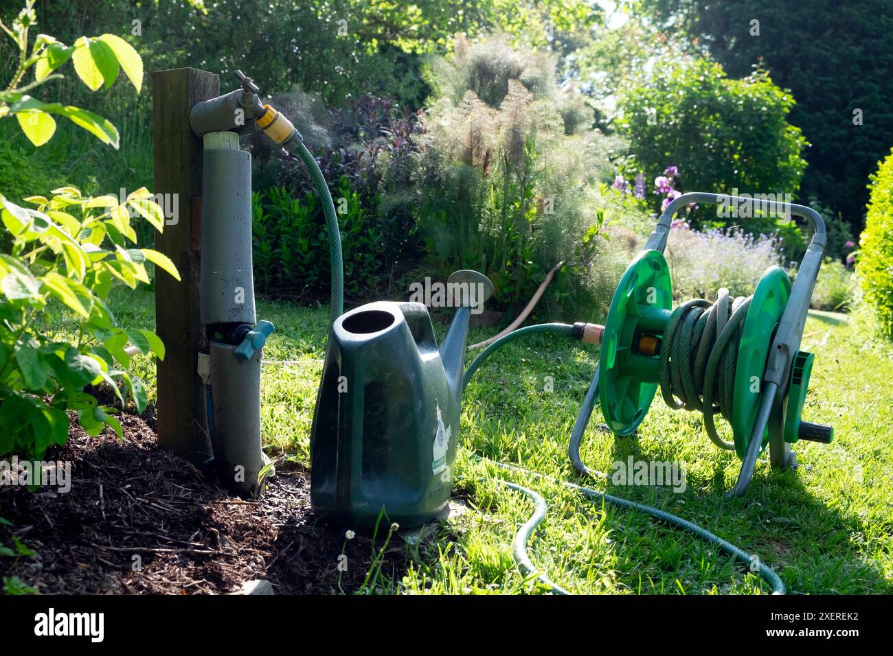 Water tap, watering can and hose on reel for domestic garden irrigation ...