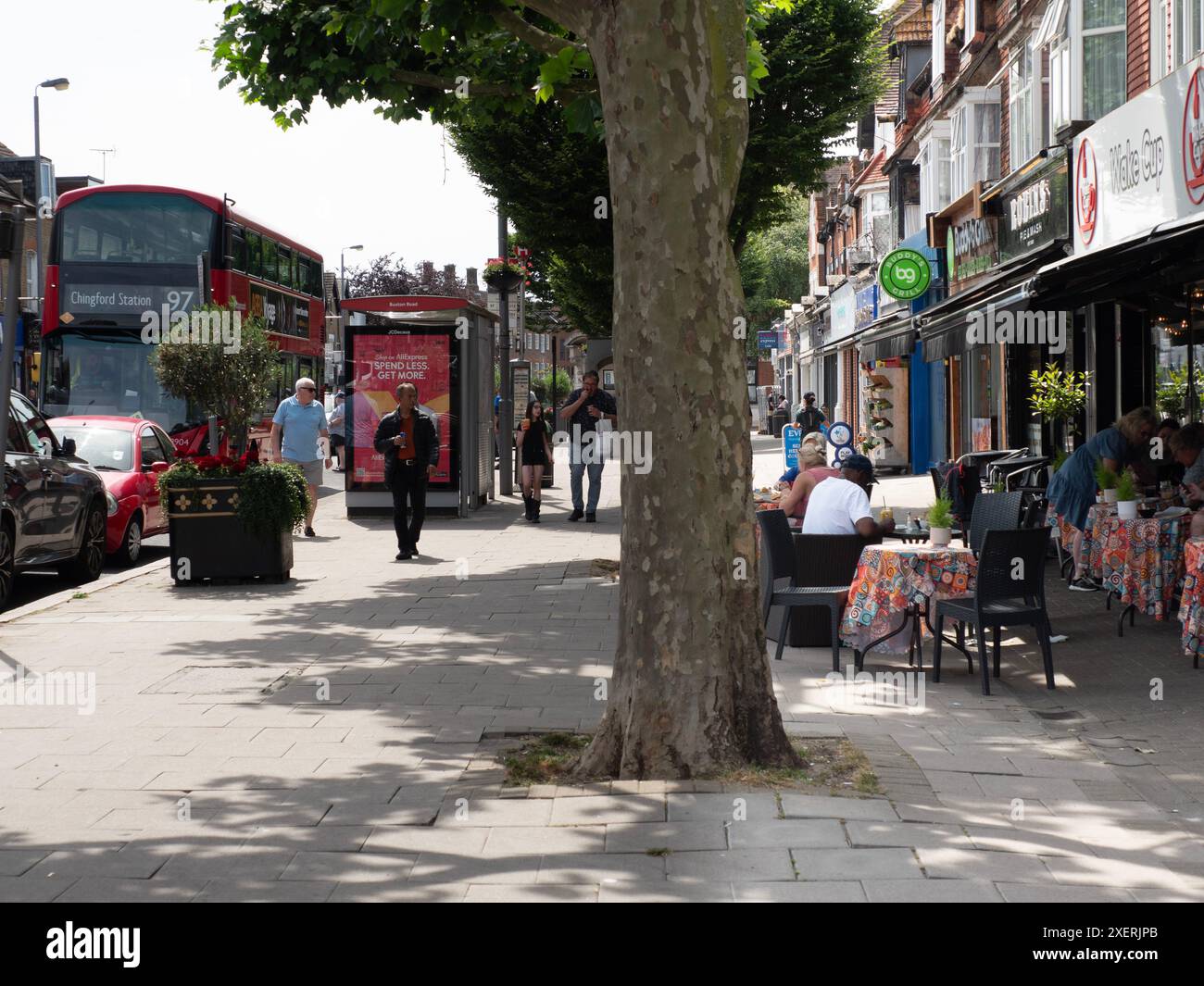 People sittng outside cafe's and bars in summer sun in Station Road ...