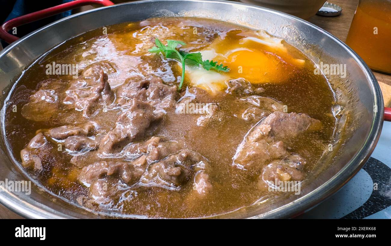 A bowl of stew with Vietnamese meat and an egg, all cooked in a rich ...
