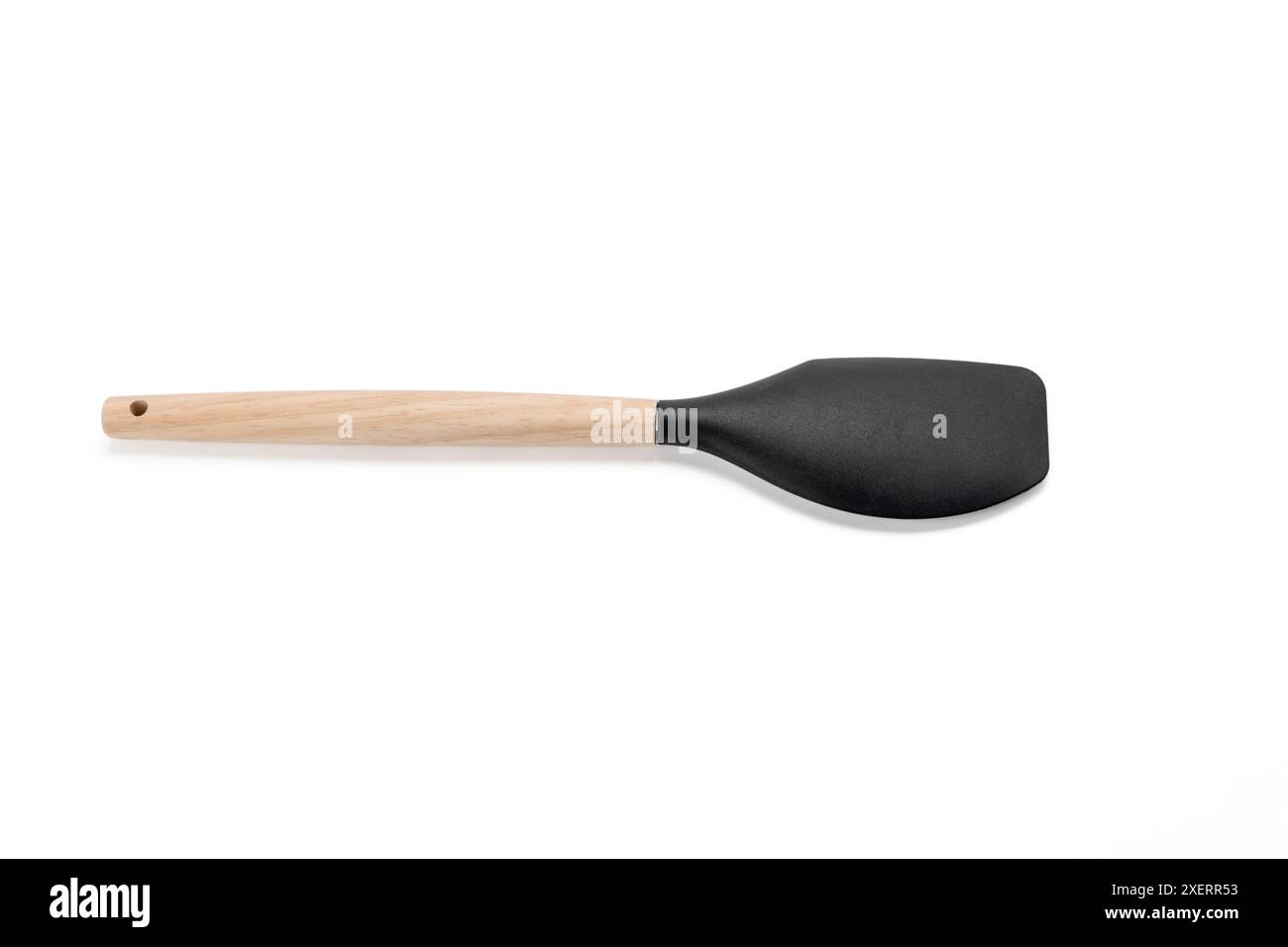 Black spatula with wooden handle. The spatula is long and thin. He sits ...