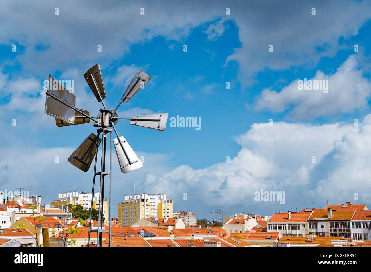 Windmill stands tall above the rooftops of lisbon, contrasting with the city's modern buildings ...