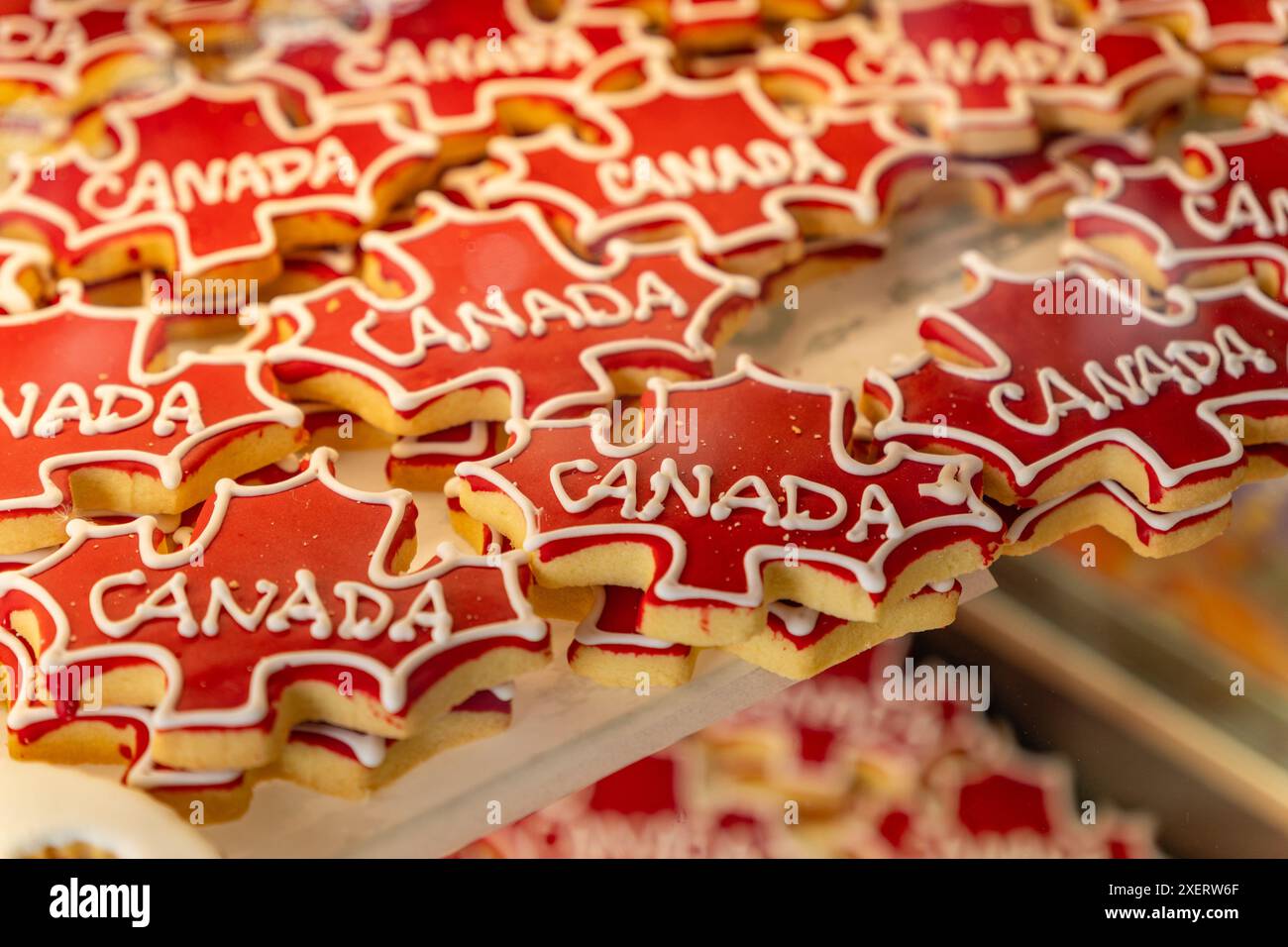 Retail display of bright red cookies shaped like a maple leaf with the ...