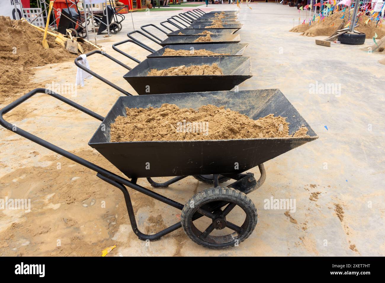 Wheelbarrows loaded with sand in a row at a traditional sand building ...