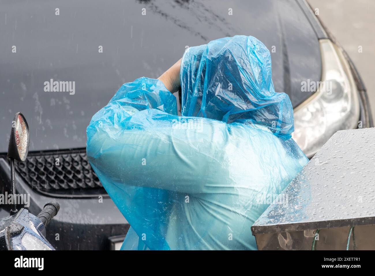 The female rider take off the raincoat after parking the motorcycle ...