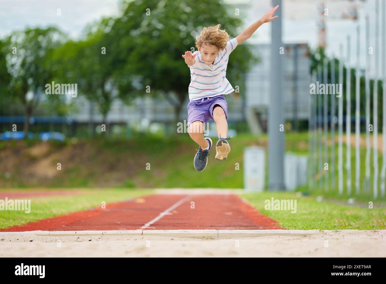 Kids long jump athletics training. Child jumping in sand pit on school ...