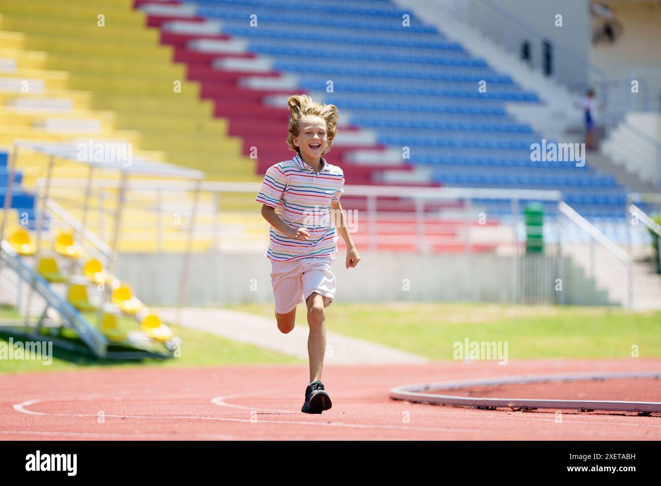 Child running on stadium. Kid exercising in athletics club. Young ...