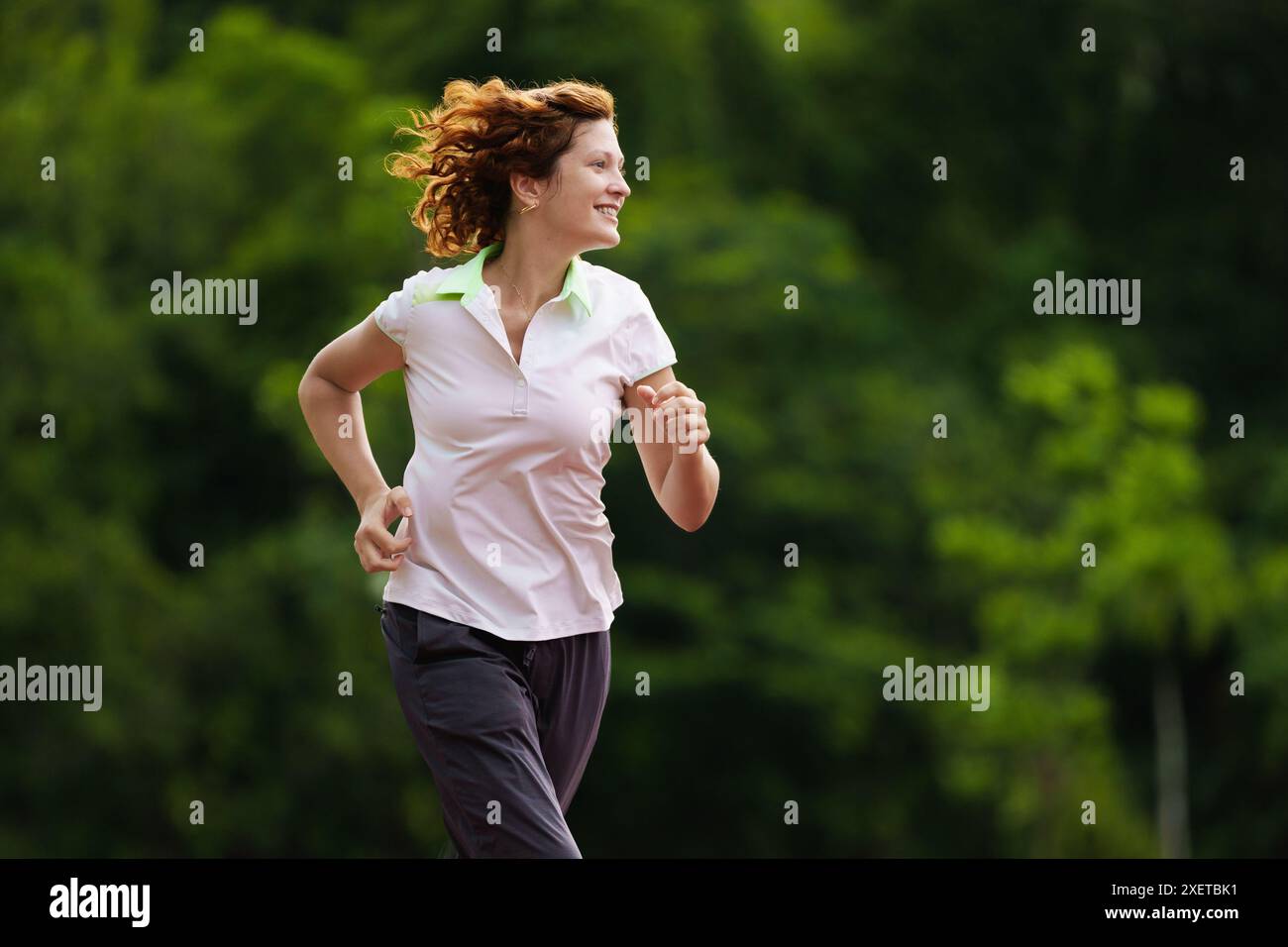 Active woman exercising. Fit slim girl running on sunny stadium in ...