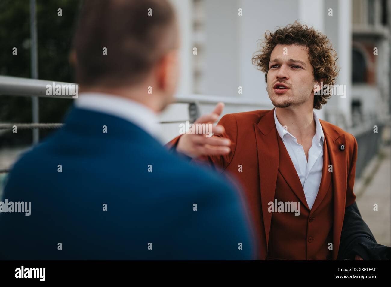 Two businessmen having a discussion outdoors in a serious conversation ...
