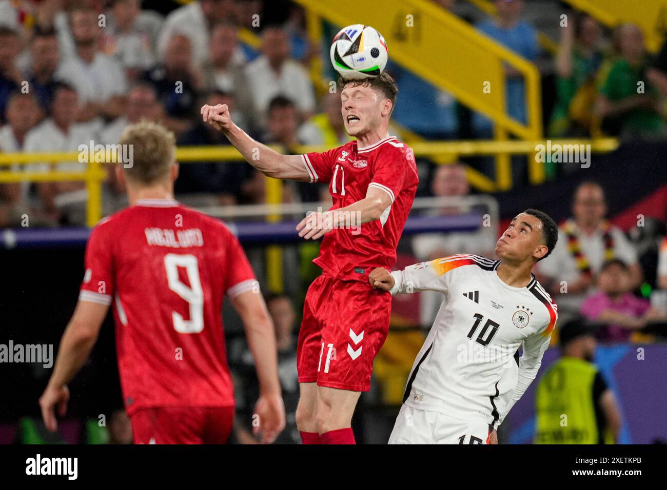 Denmark's Andreas Skov Olsen hits a header next to Germany's Jamal ...