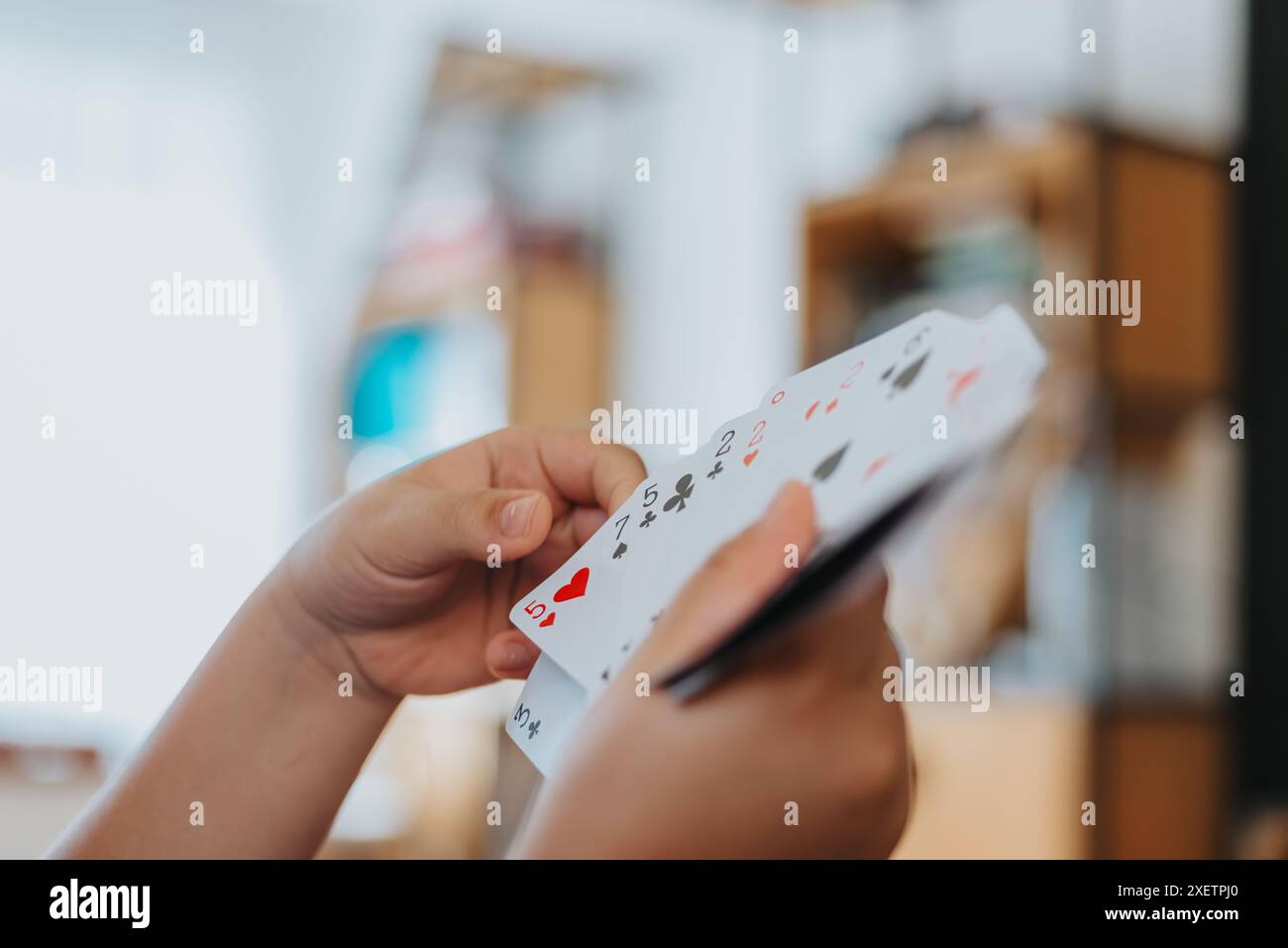 Child playing cards at home, having fun with a family game Stock Photo ...
