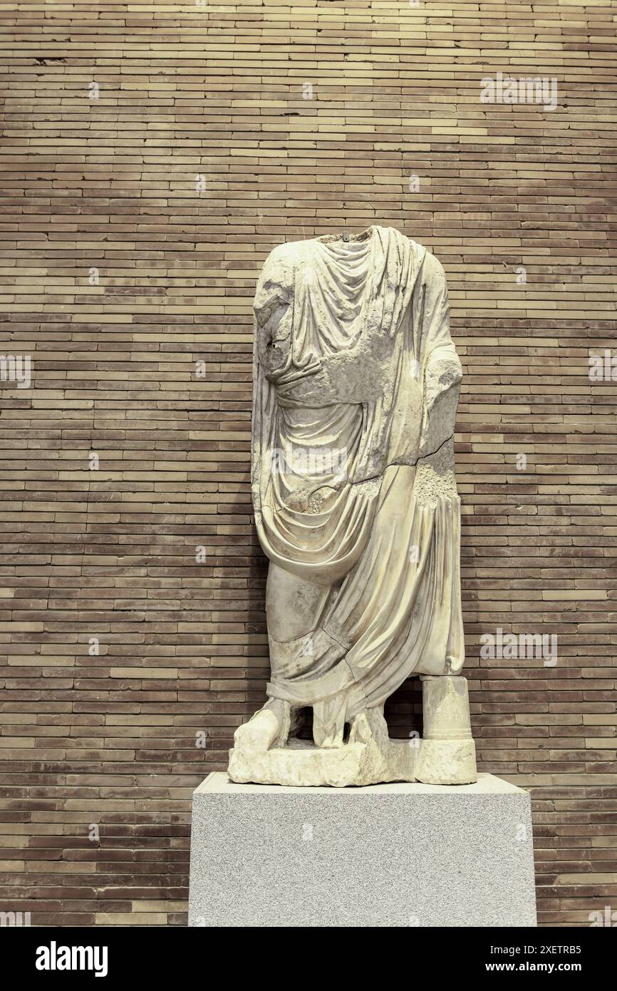 A headless ancient marble statue of a robed figure, showcasing the ...