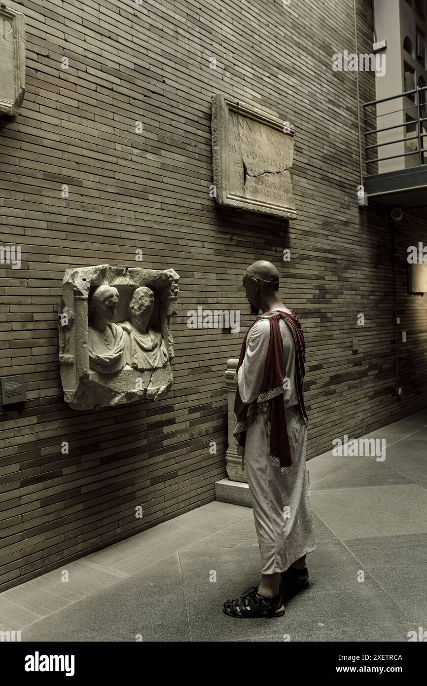 A man dressed in traditional Roman attire observes ancient Roman ...