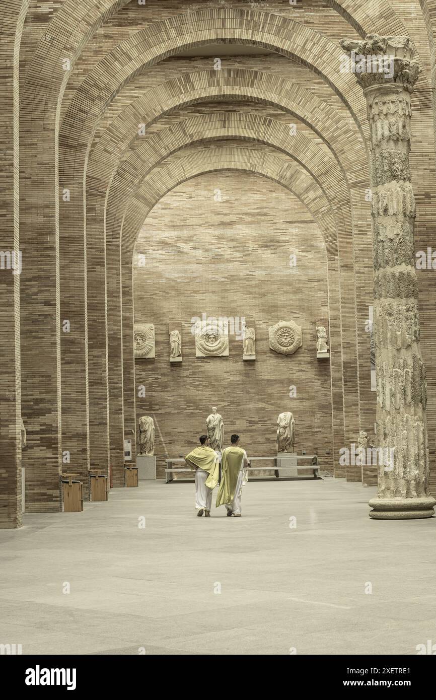 wo visitors dressed in Roman attire walk through the grand hall of the ...