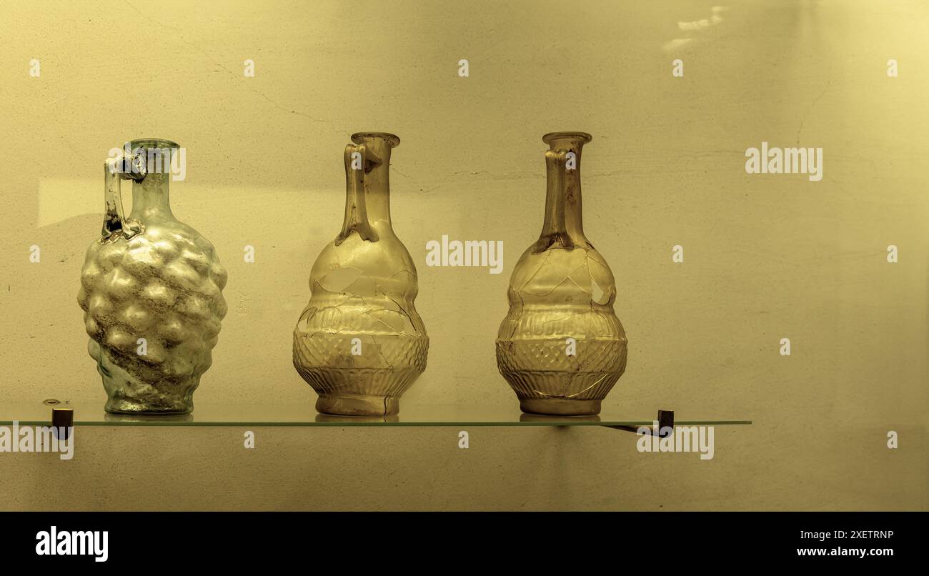 An ancient Roman green glass vase with intricate design. Features a ...