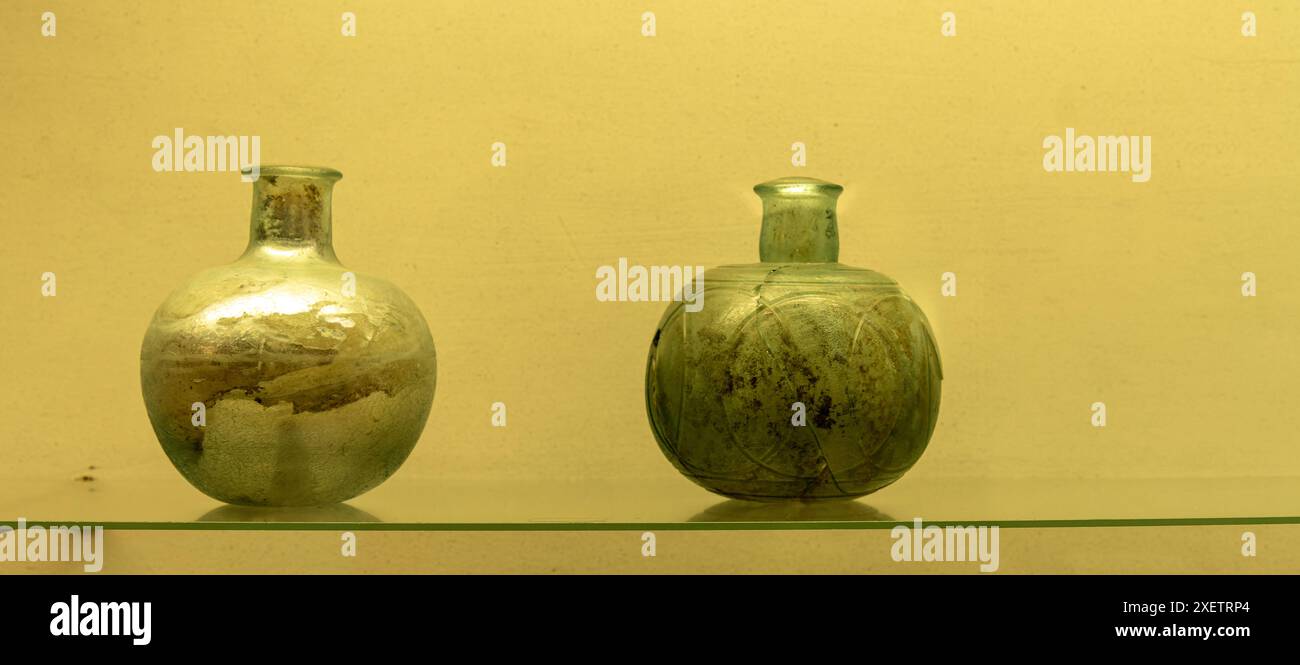 An ancient Roman green glass vase with intricate design. Features a ...