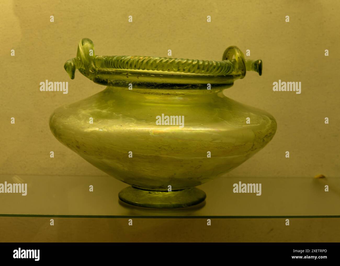 An ancient Roman green glass vase with intricate design. Features a ...