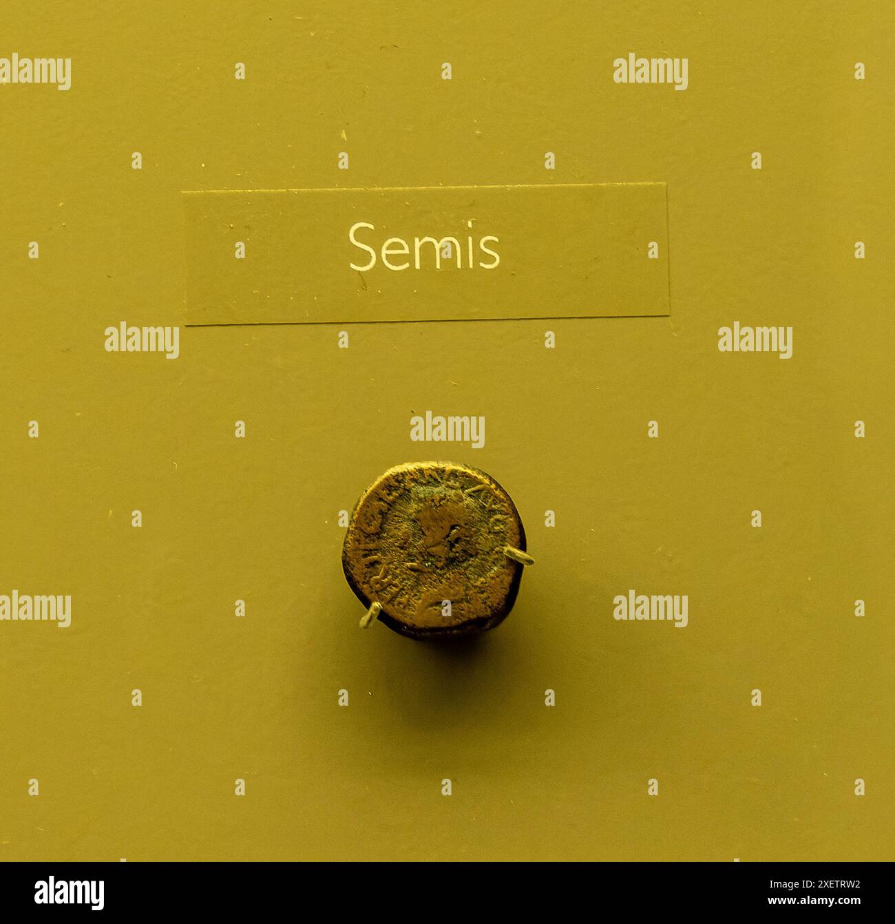 Close-up view of an ancient Roman semis coin in a museum exhibit ...