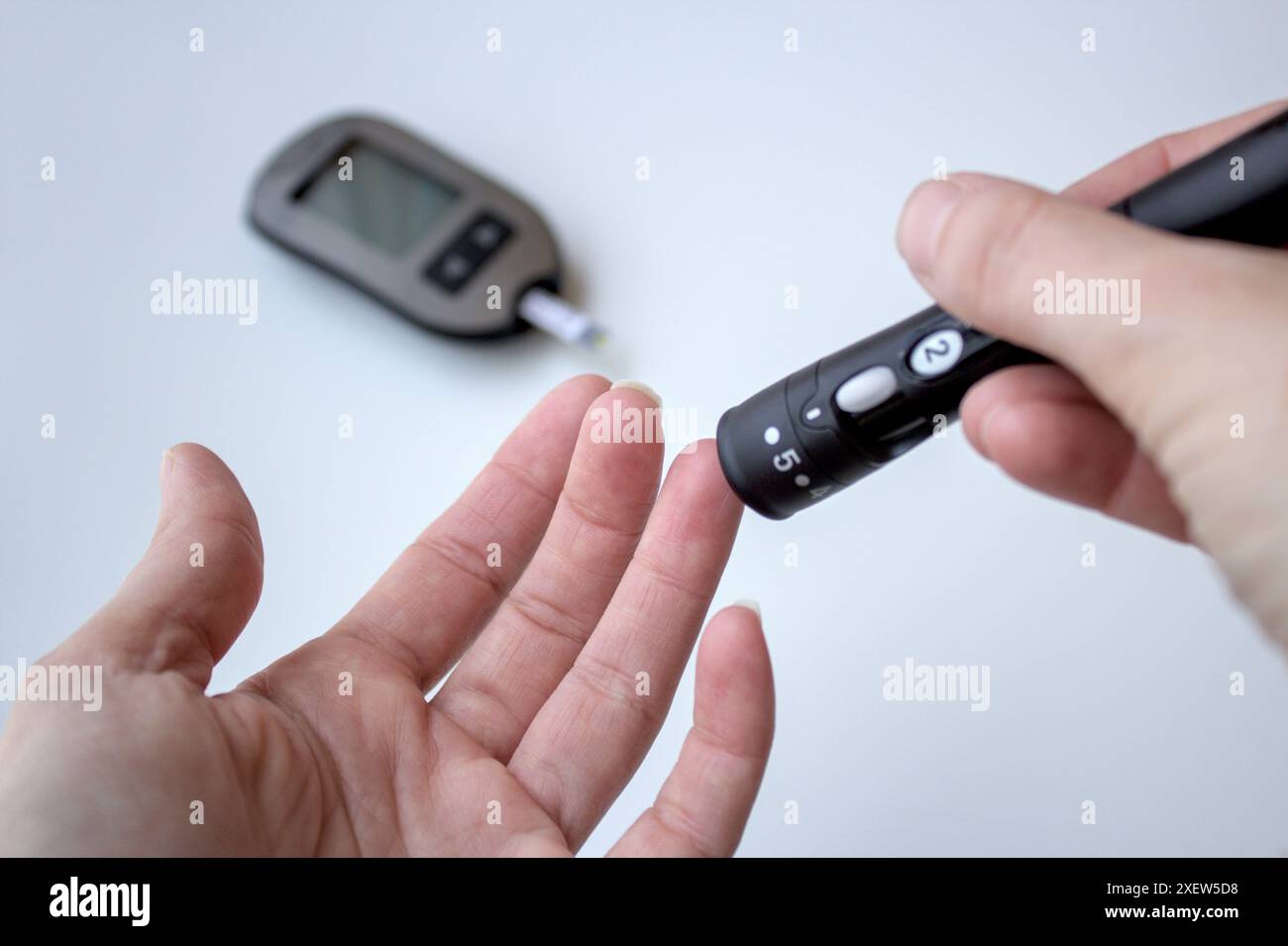 Diabetes screening test. Patient measuring blood glucose by pricking ...